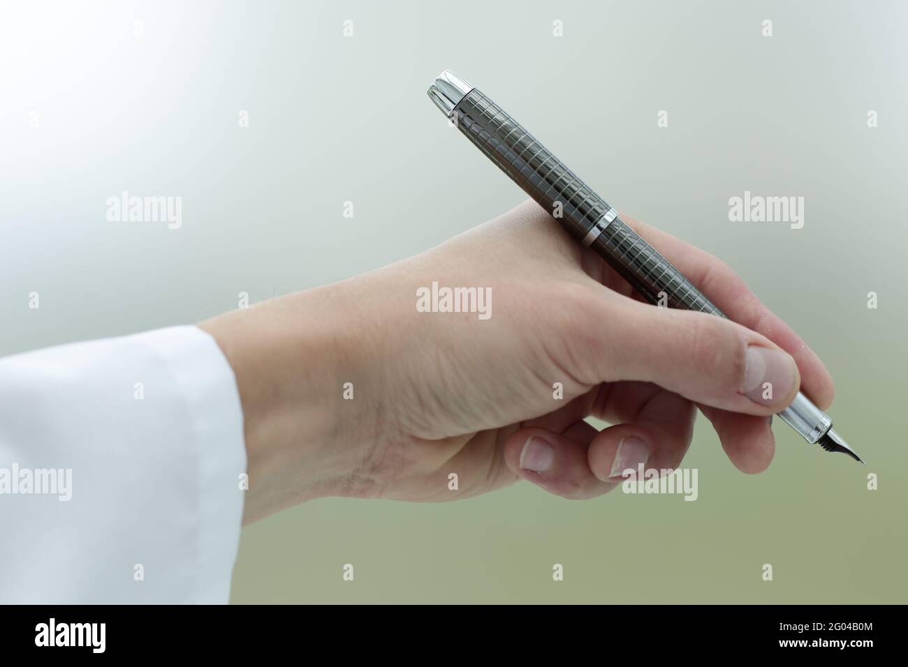 Doctor's hand holding a fountain pen Stock Photo - Alamy