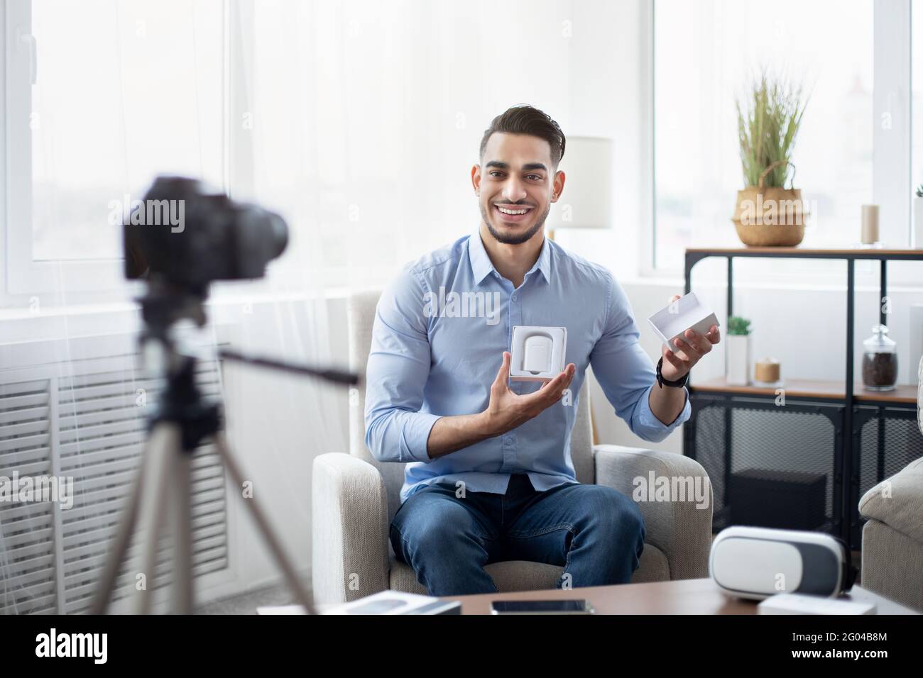 Arab male vlogger making video review of new wireless earphones, using ...