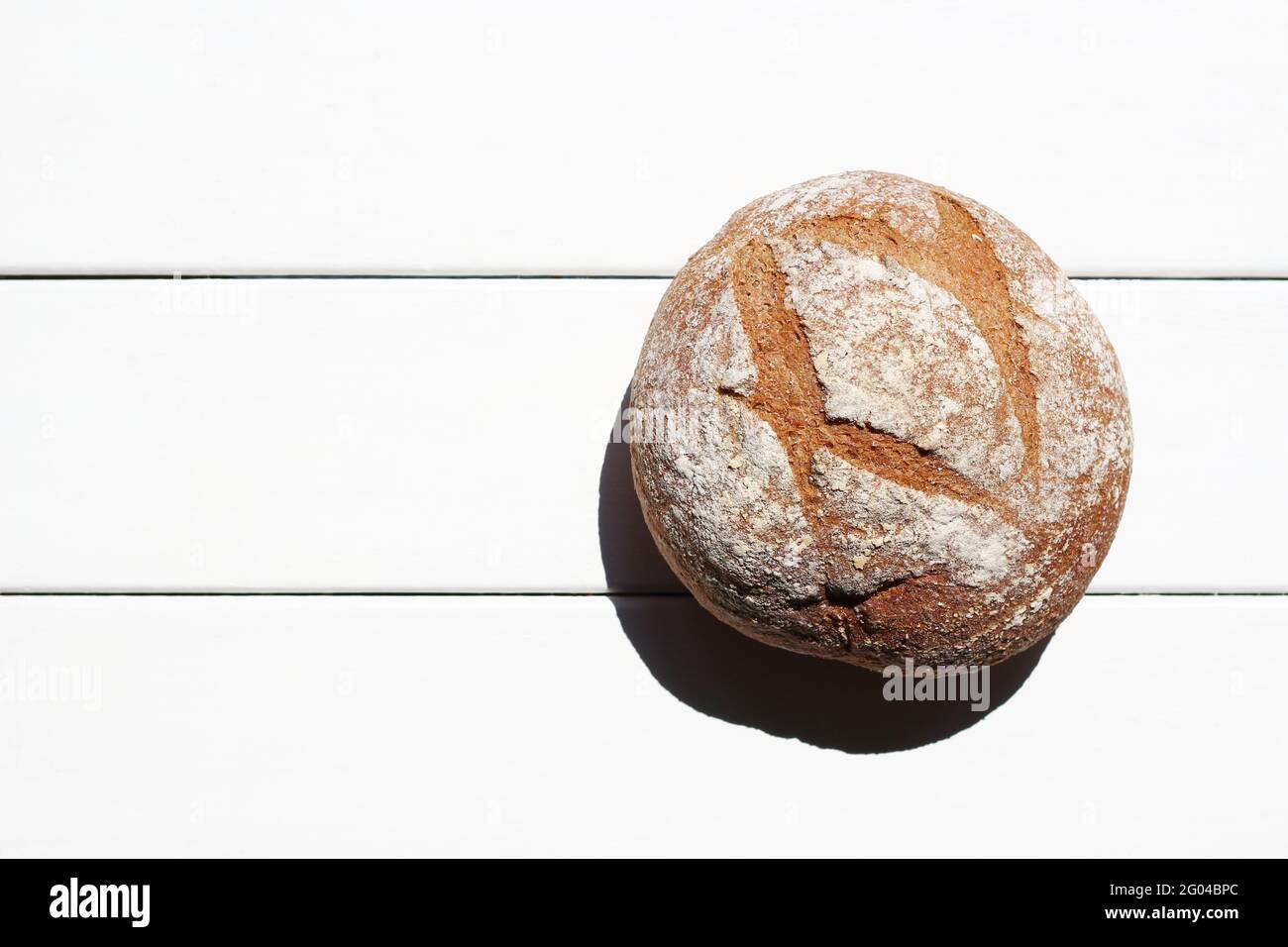 Sourdough bread, tasty round dark bread in the sunlight, placed on a ...