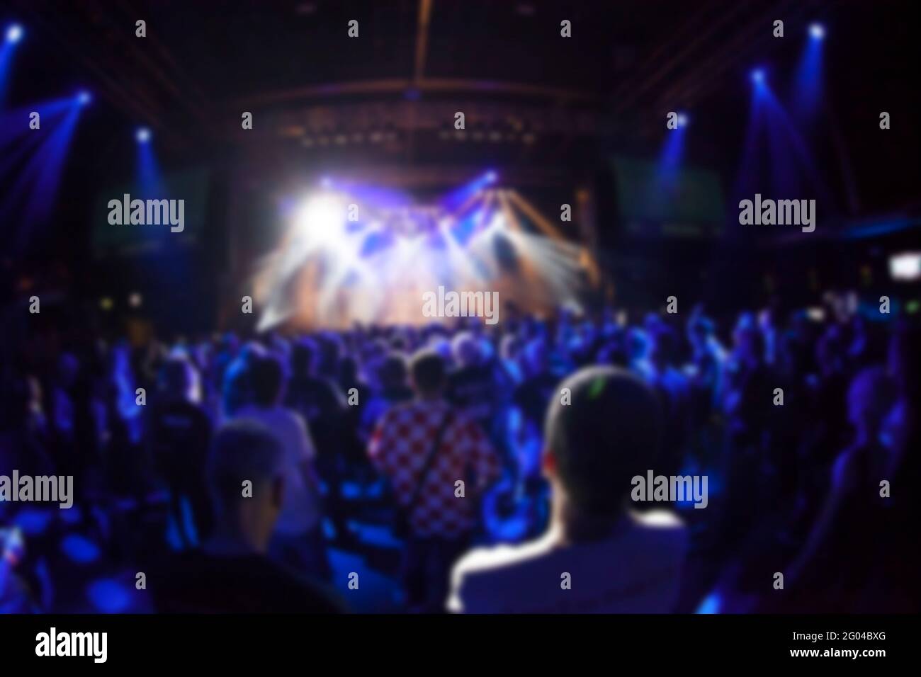 Concert crowd inside a venue, lens flare and smoke are visible Stock ...