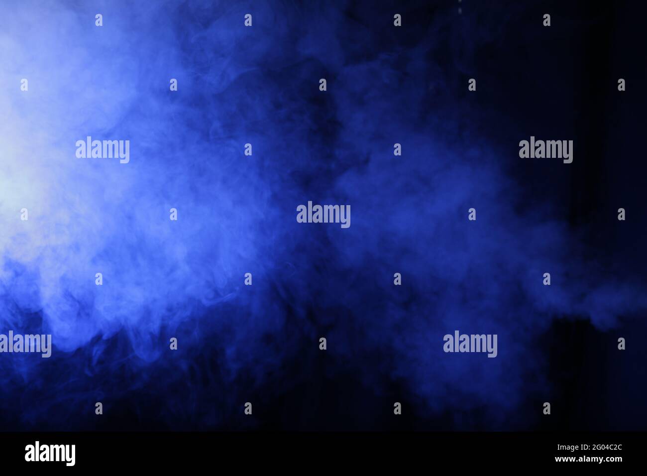 Artificial smoke in blue light on black background Stock Photo - Alamy