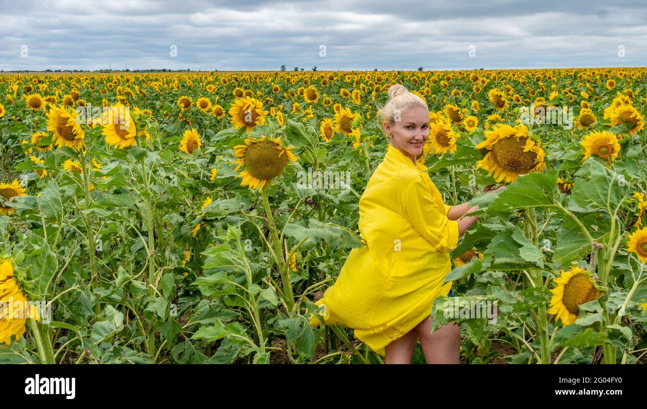 lady in yellow dress young with charismatic appearance blue clouds on a ...