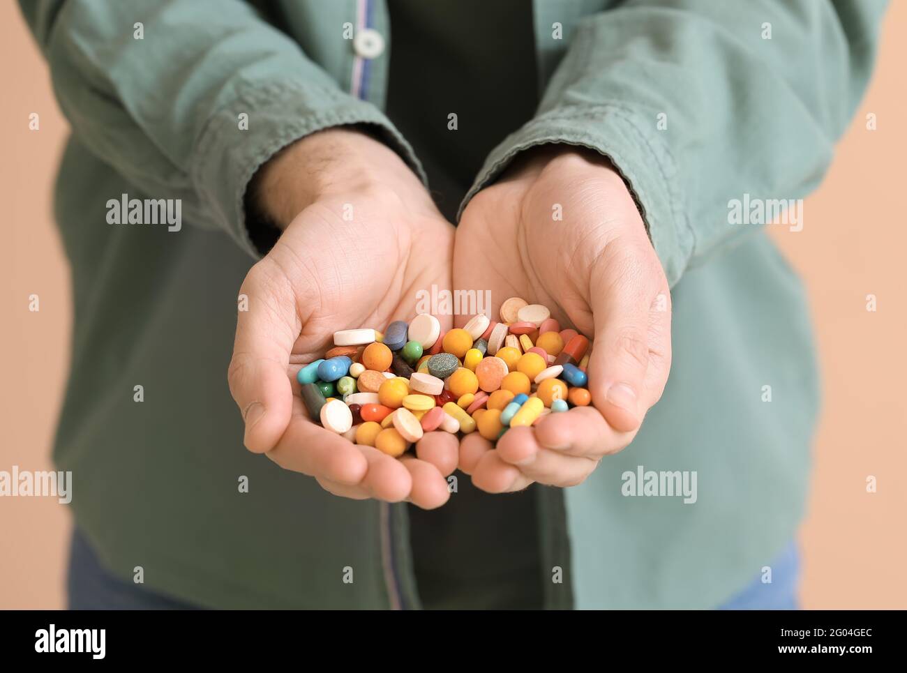 Handsome young man with pills on color background, closeup Stock Photo ...