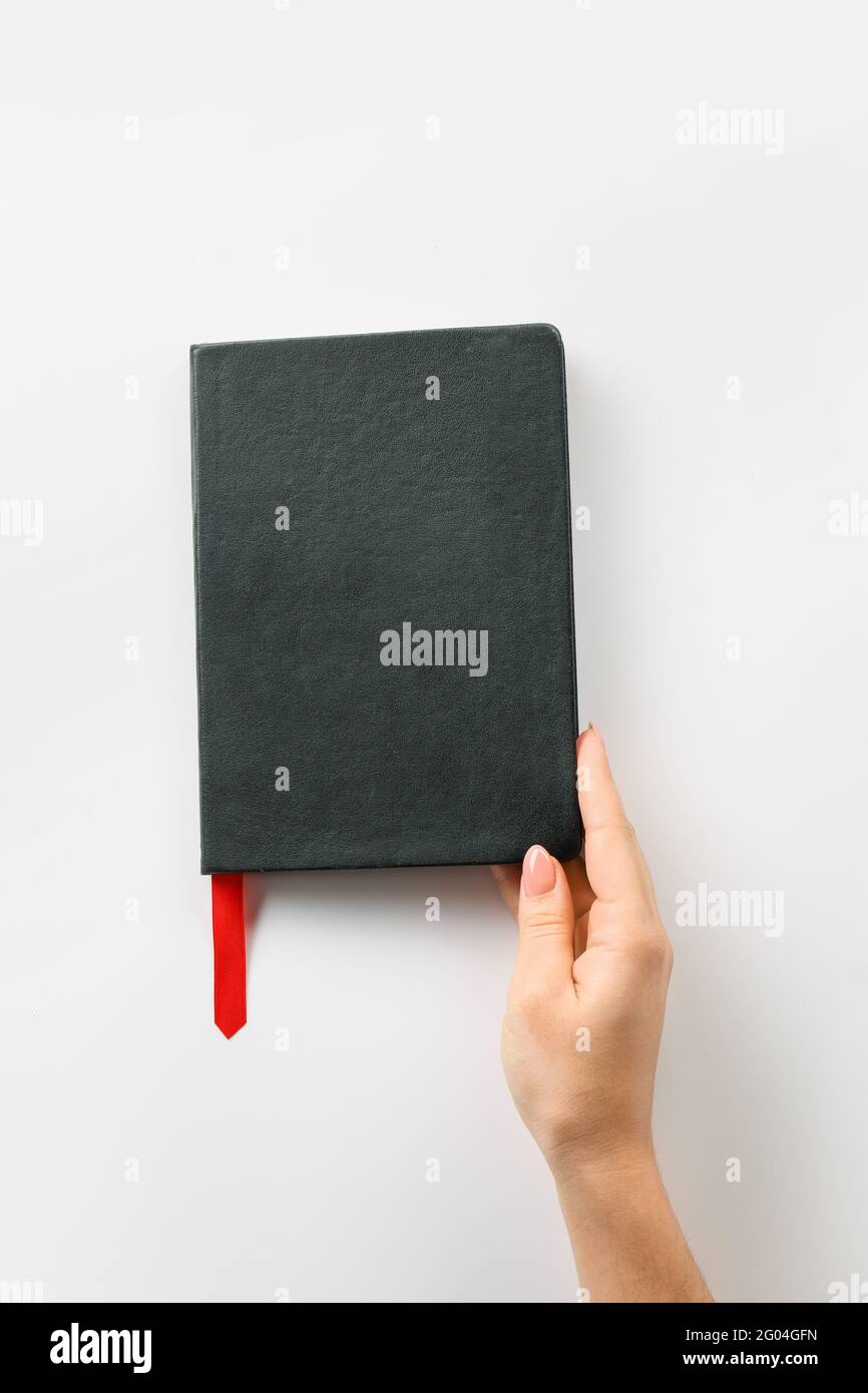 Female hand and book with bookmark on white background Stock Photo - Alamy