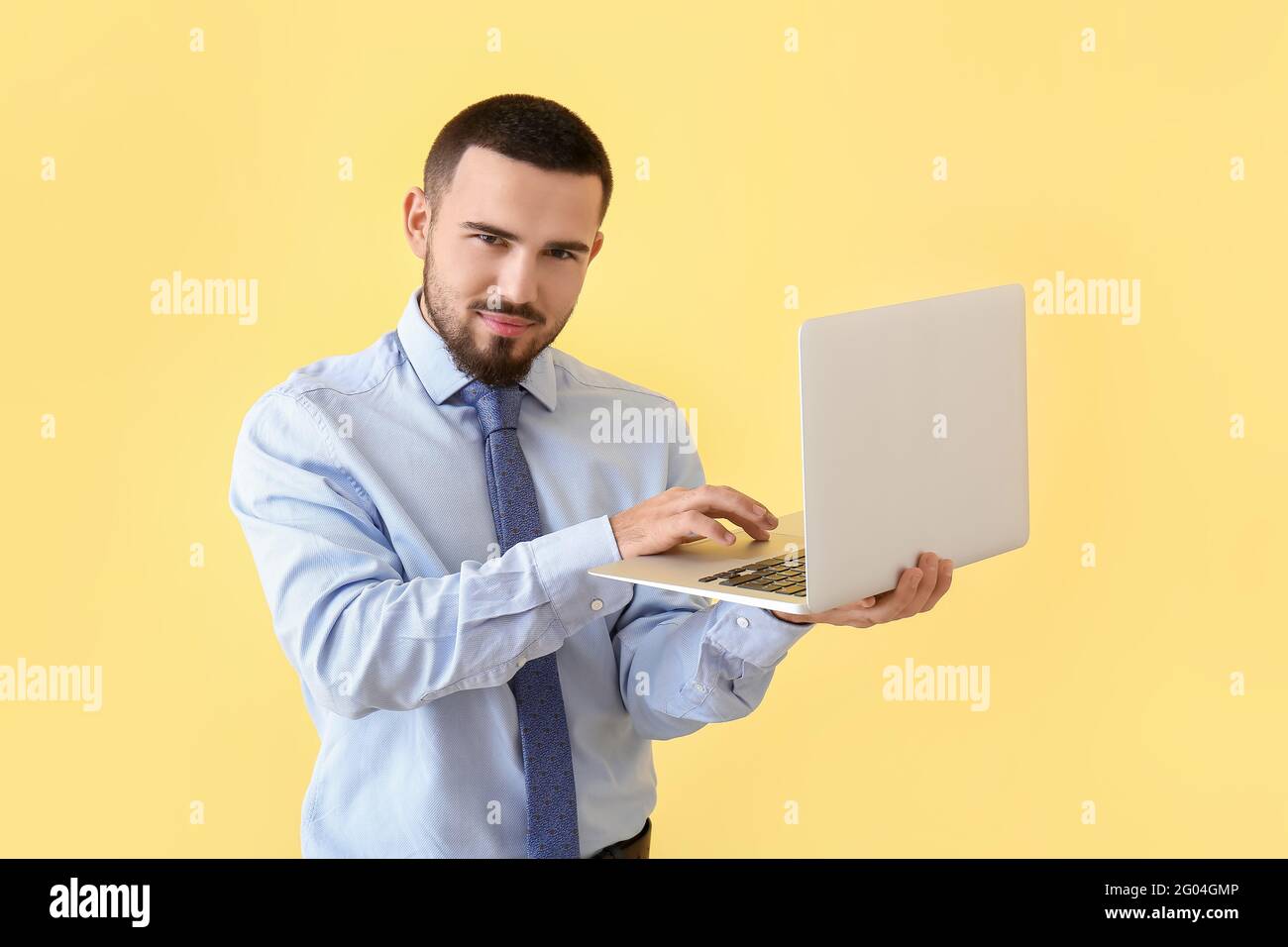 Young businessman using laptop on color background Stock Photo - Alamy