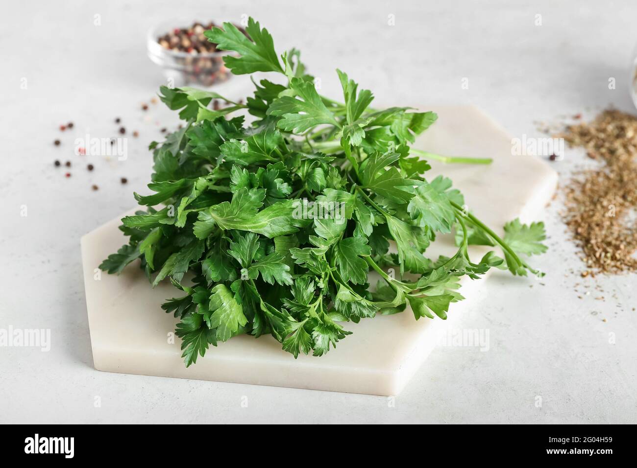 Board with fresh parsley on light background Stock Photo - Alamy