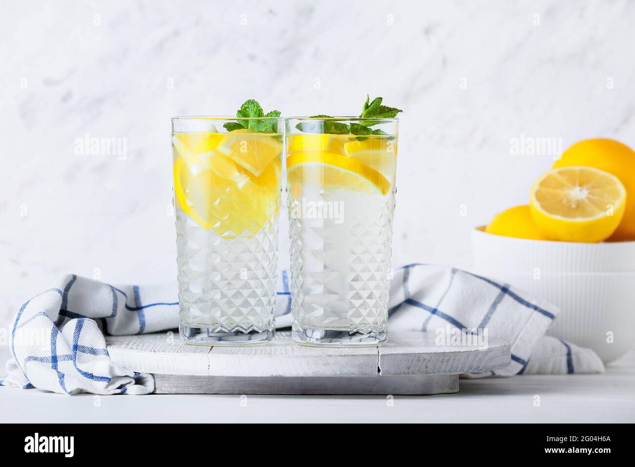 Glasses of tasty cold lemonade on light background Stock Photo - Alamy