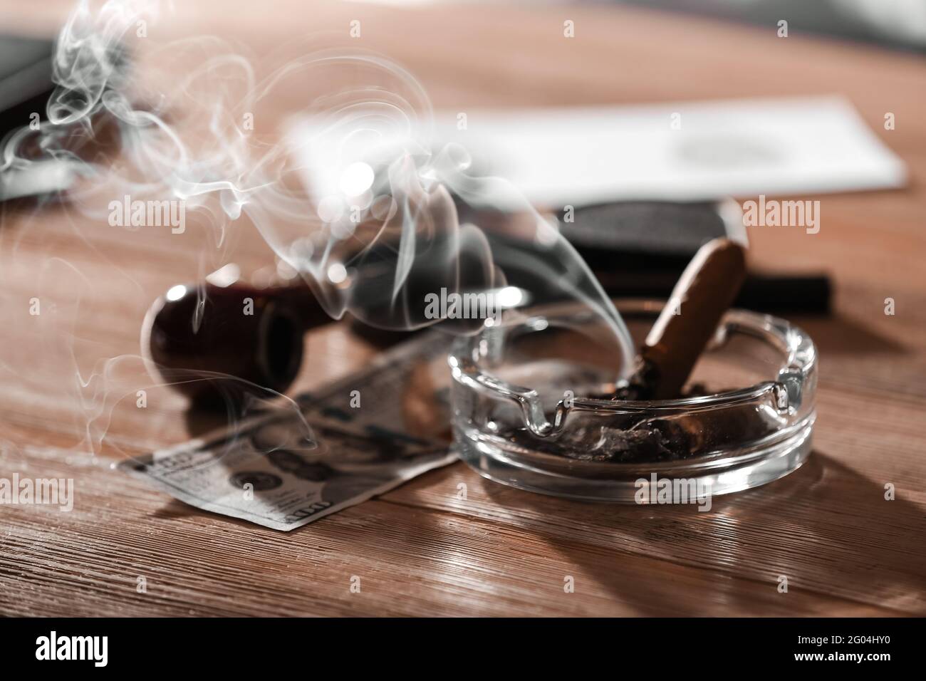 Ash tray, pipe and money on table of detective Stock Photo - Alamy