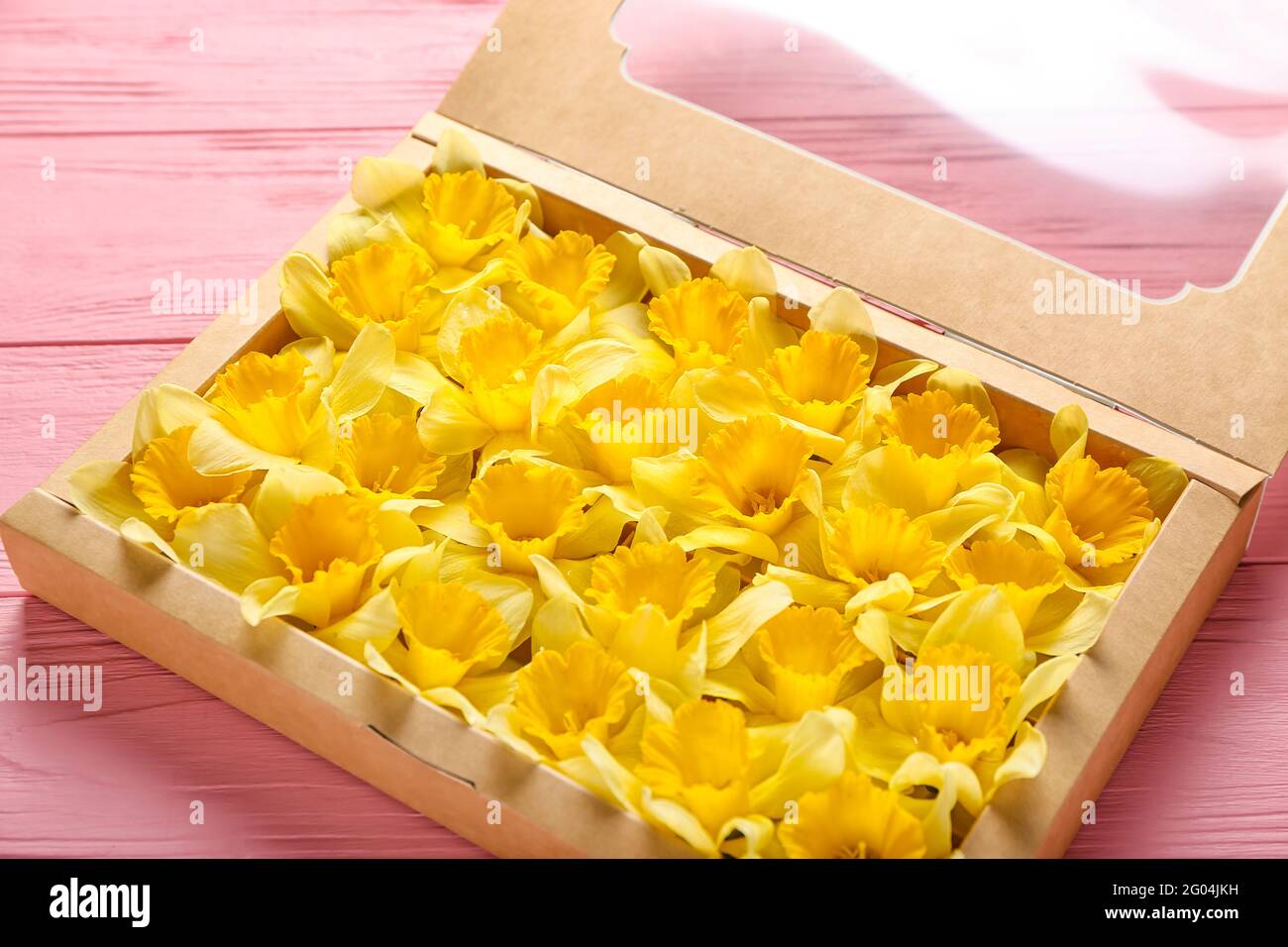 Box with beautiful daffodils on color wooden background Stock Photo - Alamy