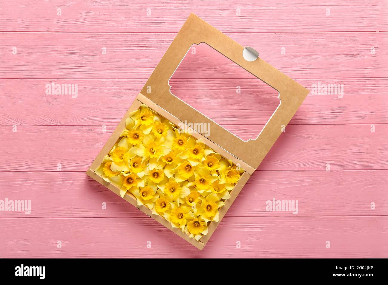 Box with beautiful daffodils on color wooden background Stock Photo - Alamy