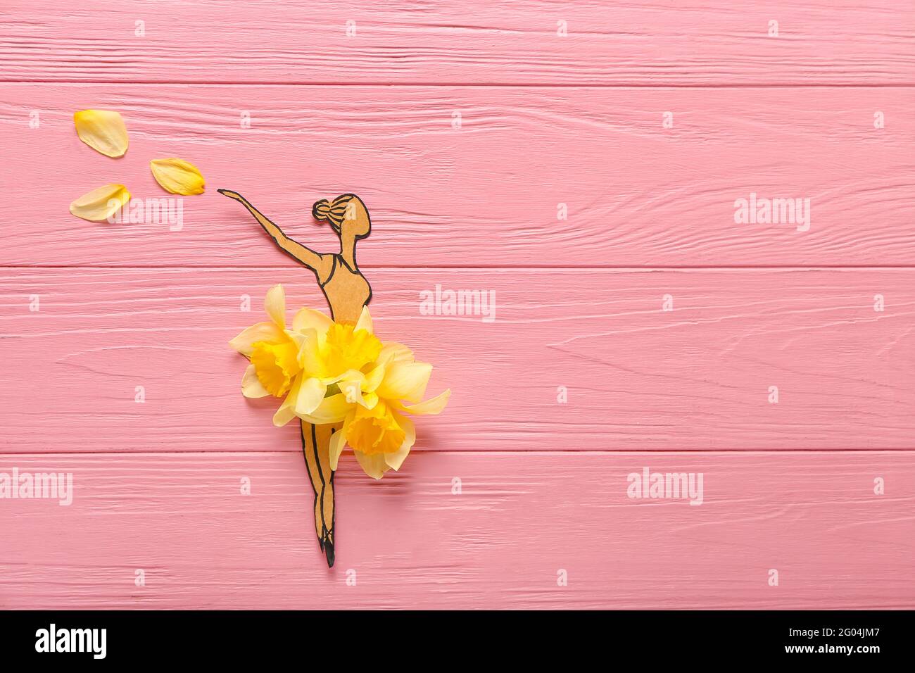 Paper ballerina figure with beautiful daffodils on color wooden ...