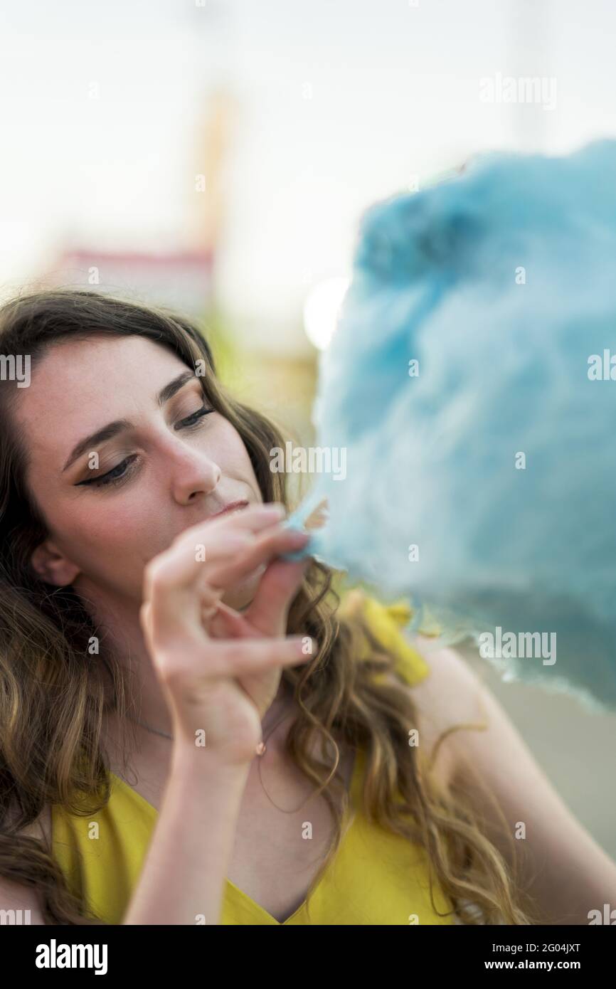 Vertical shot of a Caucasian female taking a piece of her blue cotton ...