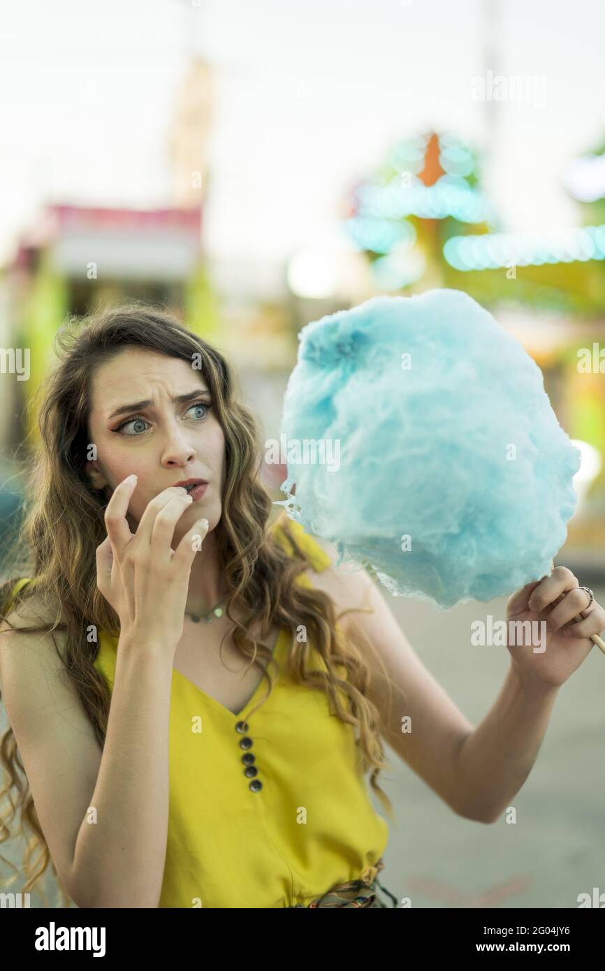 Vertical shot of a Caucasian female taking a piece of her blue cotton ...