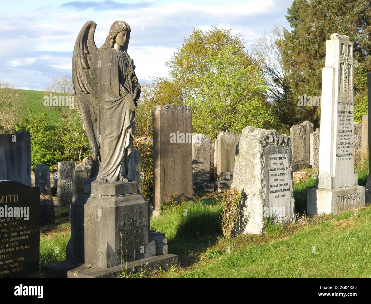A tall stone statue of a guardian angel is one of the memorials amongst ...