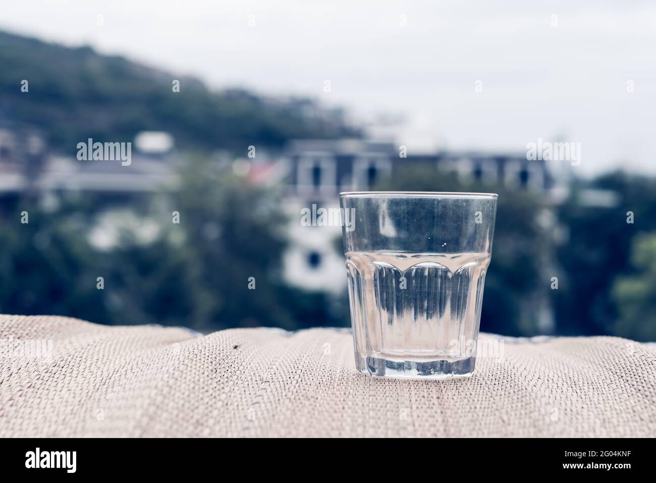 Close-up empty shabby old glass with limescale. Textured bamboo wooden ...
