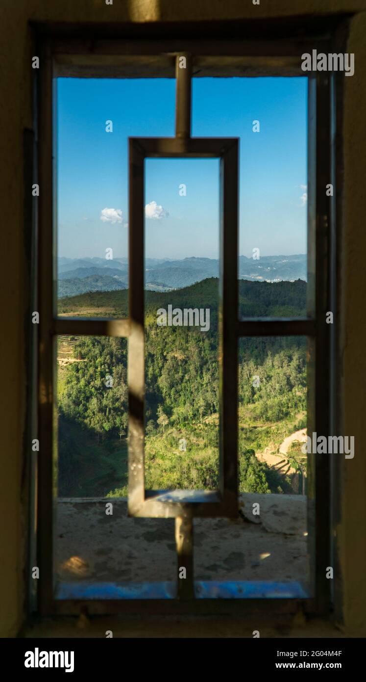 Vertical shot of old rusty window frames with mountains and greenery in ...