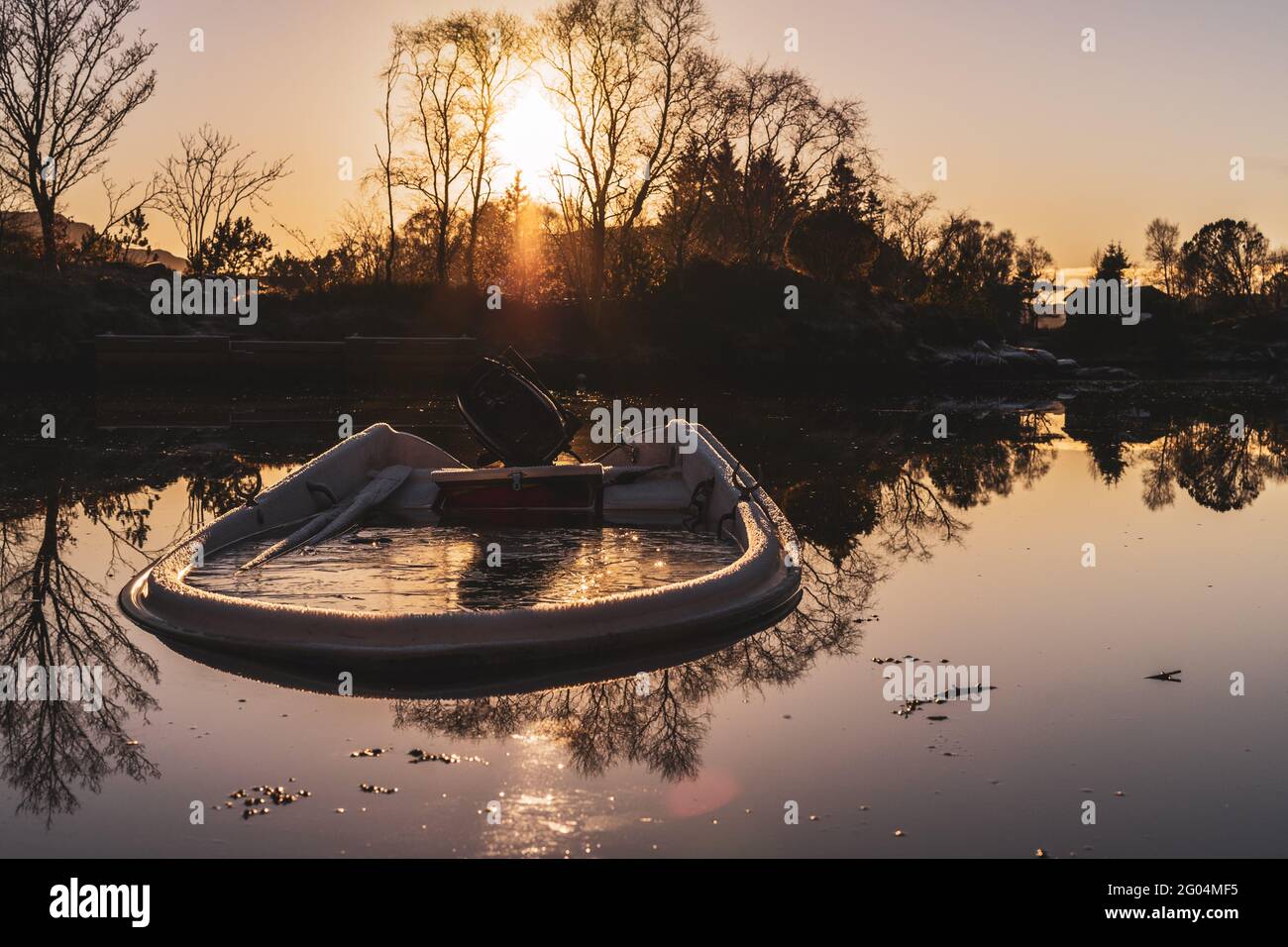 Boat filled with water in the lake at the beautiful sunset Stock Photo ...