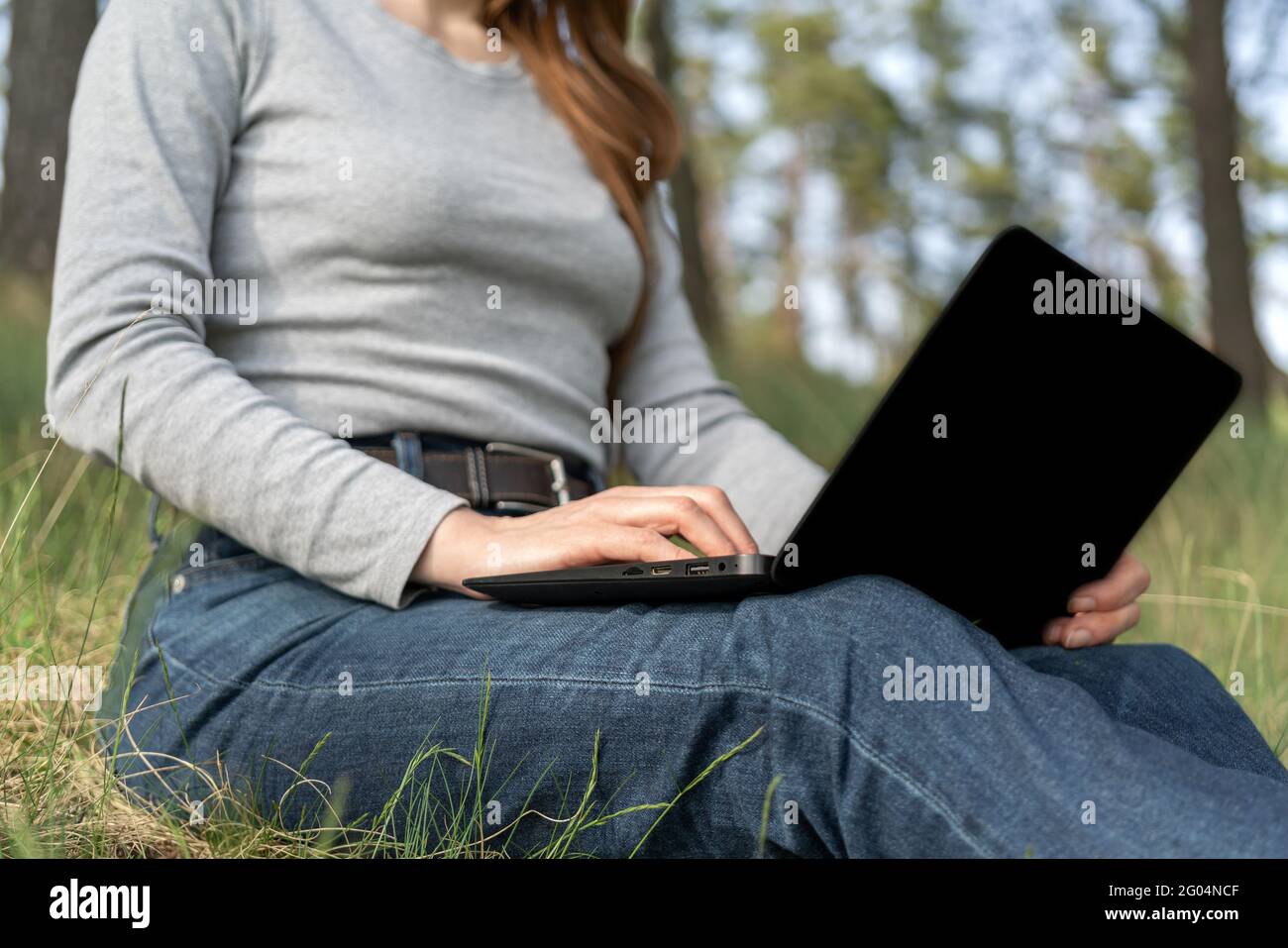 Girl holding a laptop on her lap is working outdoors Stock Photo - Alamy