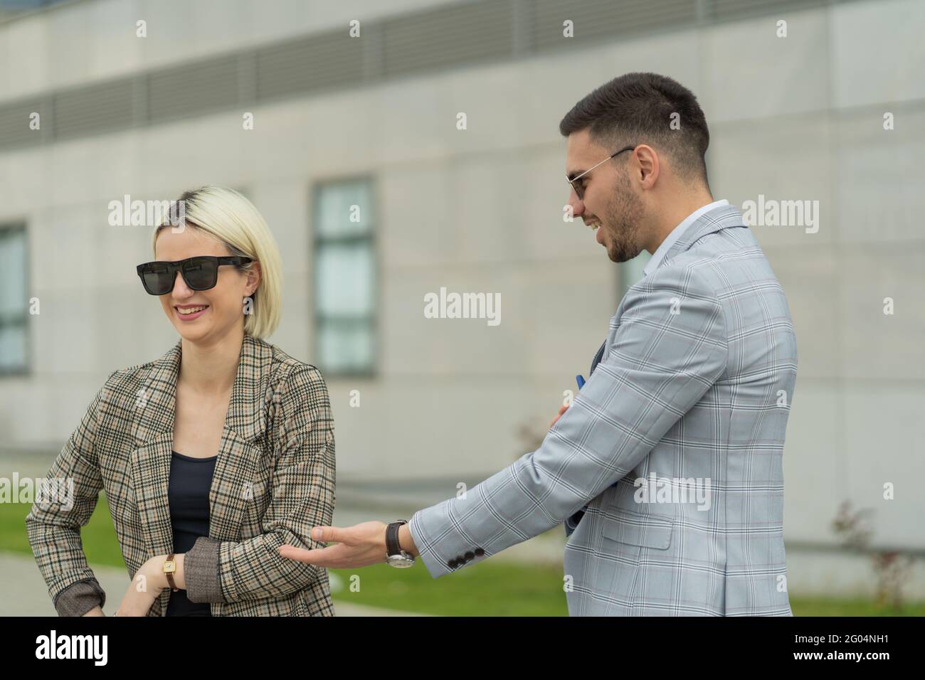 Two business partners are talking about their business while smiling ...