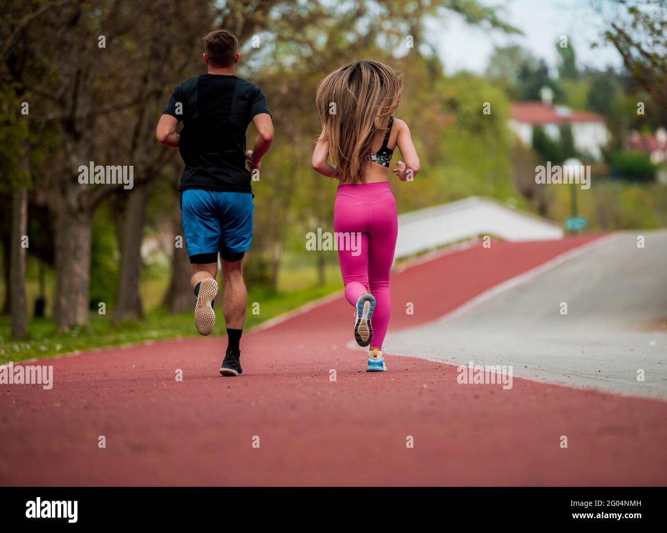 Attractive young couple in sporty outfits running together and having ...