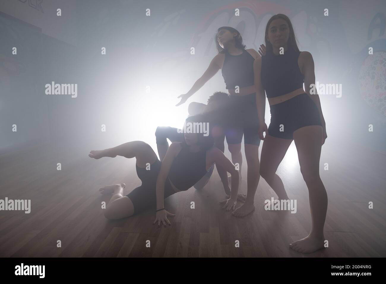 Group of multiracial dancers enjoying funky hip hop moves in dark ...