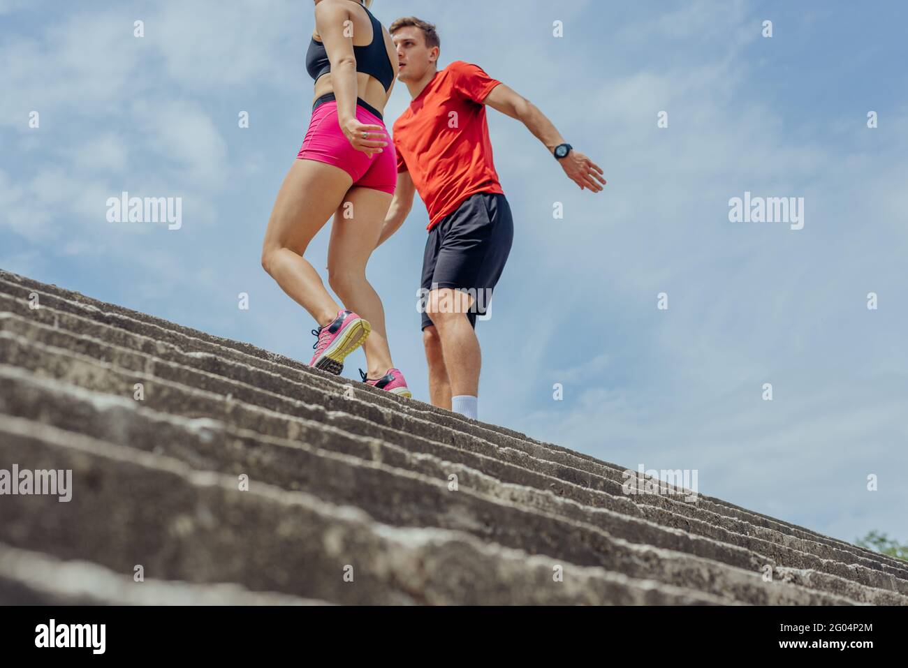 Low below angle view photo of a young caucasian couple running up ...