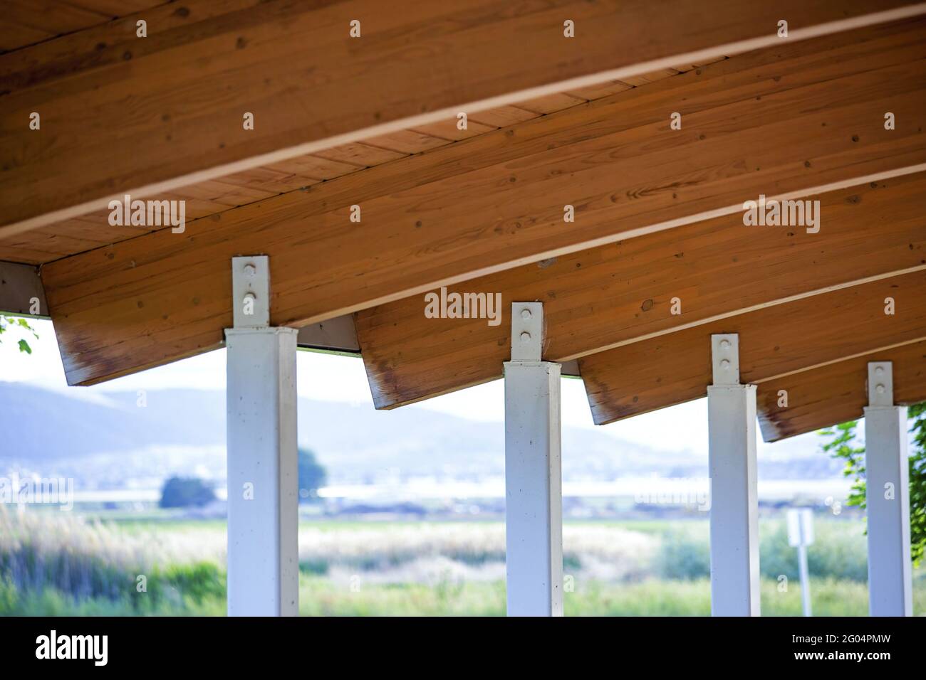 Shot of a roof made of wood and white columns in a form of a pattern ...