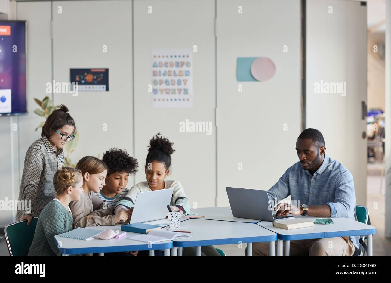 Wide angle view at students and teacher working together at modern ...