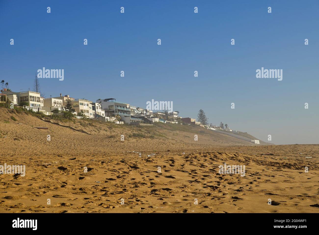 Beautiful shot of a sandy landscape with buildings on the background of ...