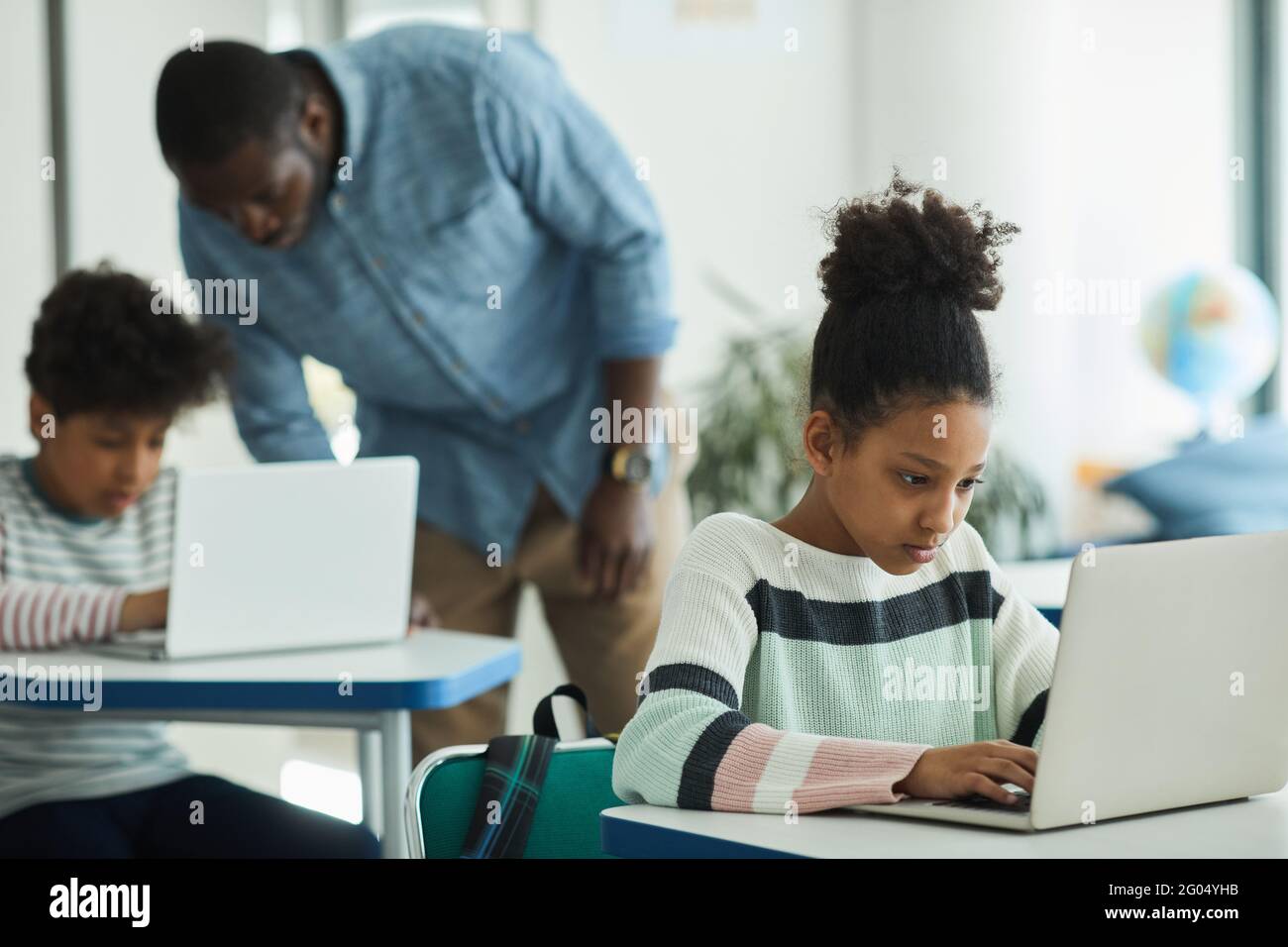 Portrait of teenage girl using laptop in school classroom, copy space ...
