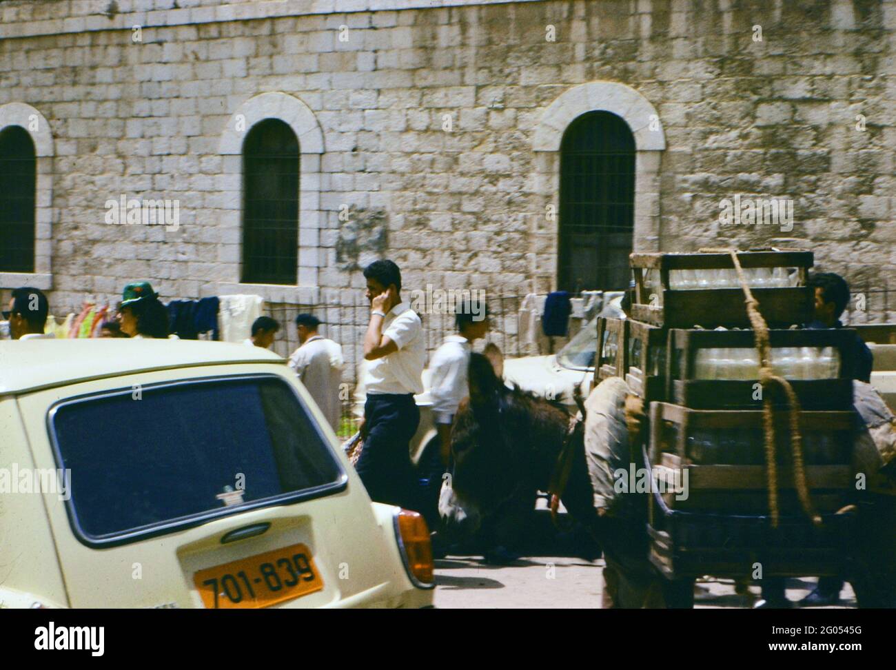 Street scene in Nazareth Israel, cars, people, donkey loaded up with ...