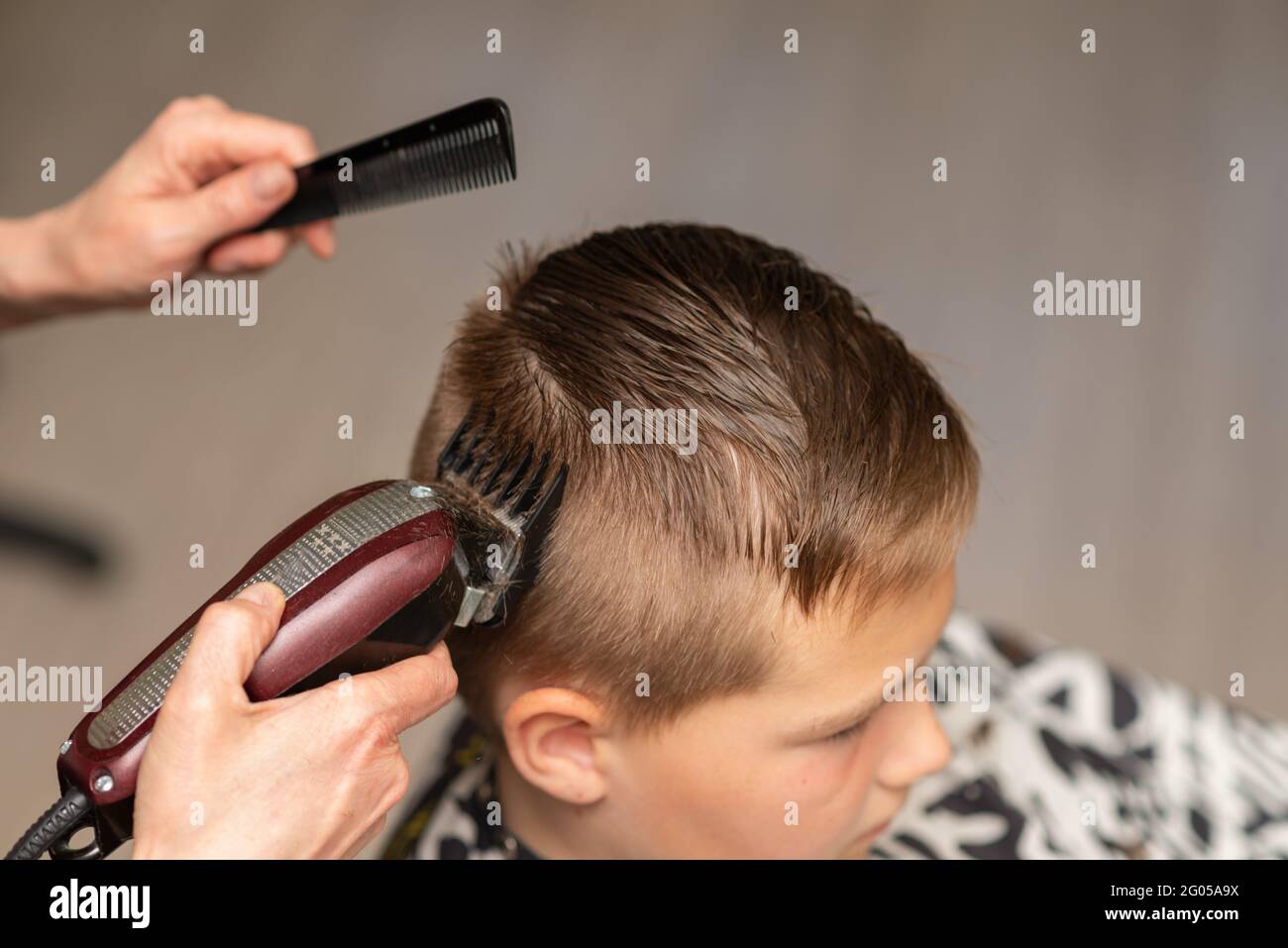 Cute kid boy have hair cut, professional barber doing haircut ...