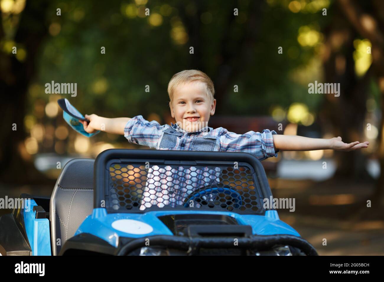 The boy plays, drives a car in the park. A cute little boy of Caucasian ...