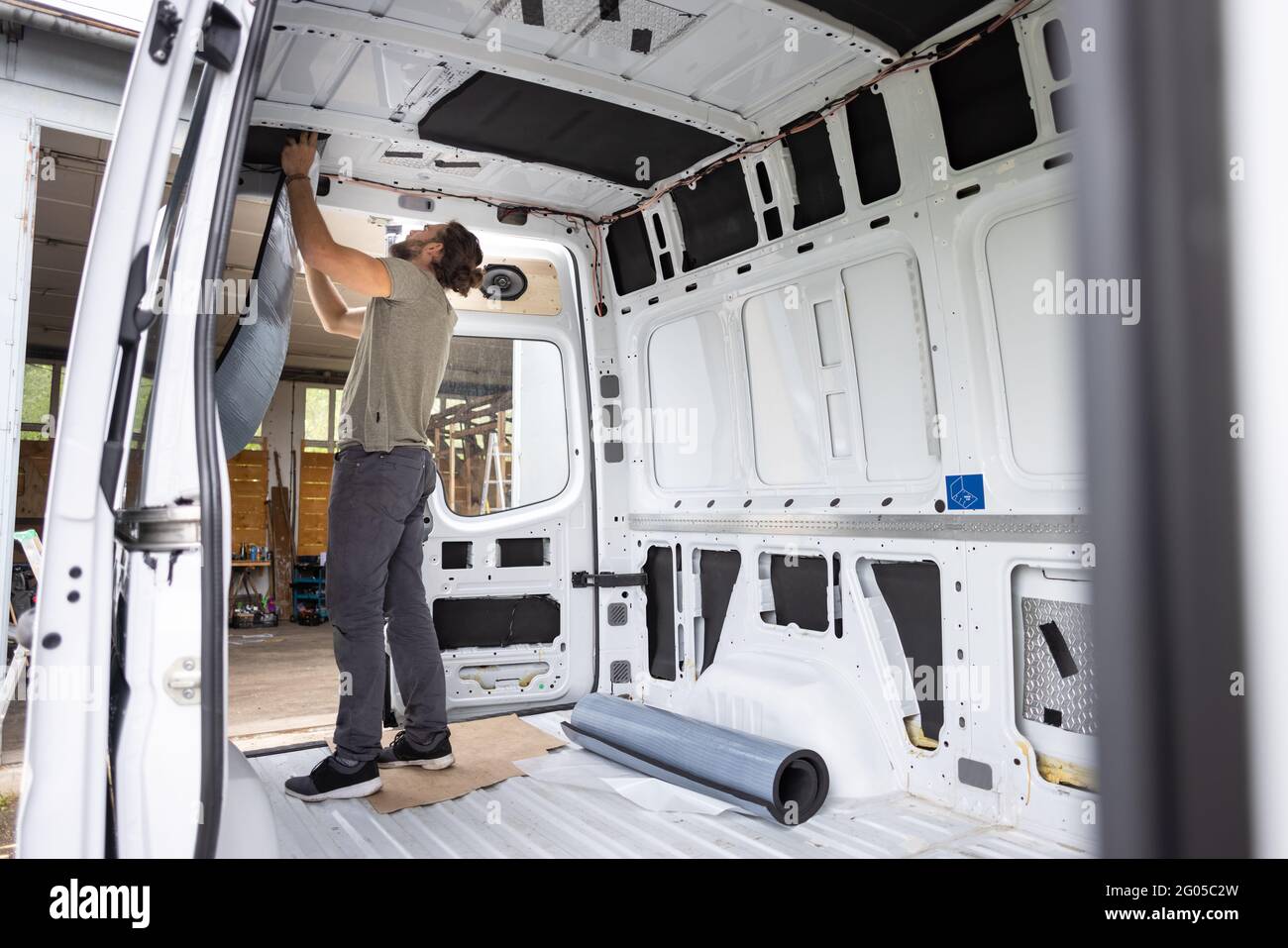 Man puts thermal insulation on the inside of a van Stock Photo - Alamy