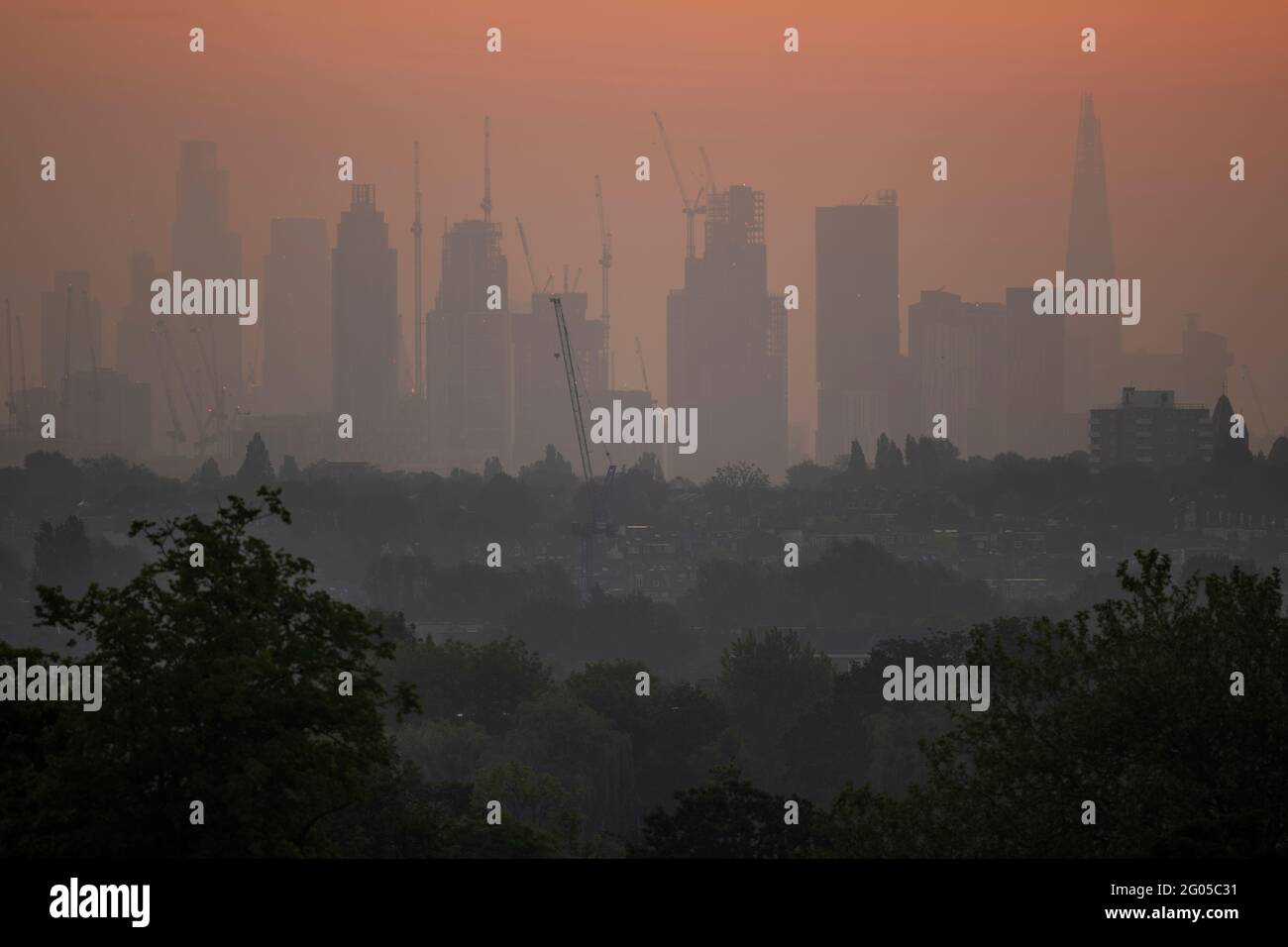 London, UK. 1 June 2021. Haze at sunrise in London as a mini-heatwave ...