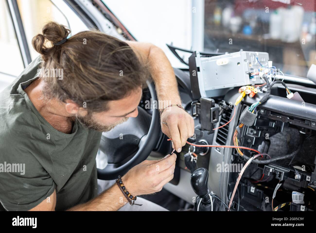 Man working on electronics inside the center console of a car Stock ...