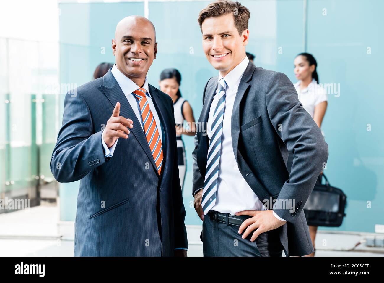 Business team with Asian and Caucasian executives having informal ...