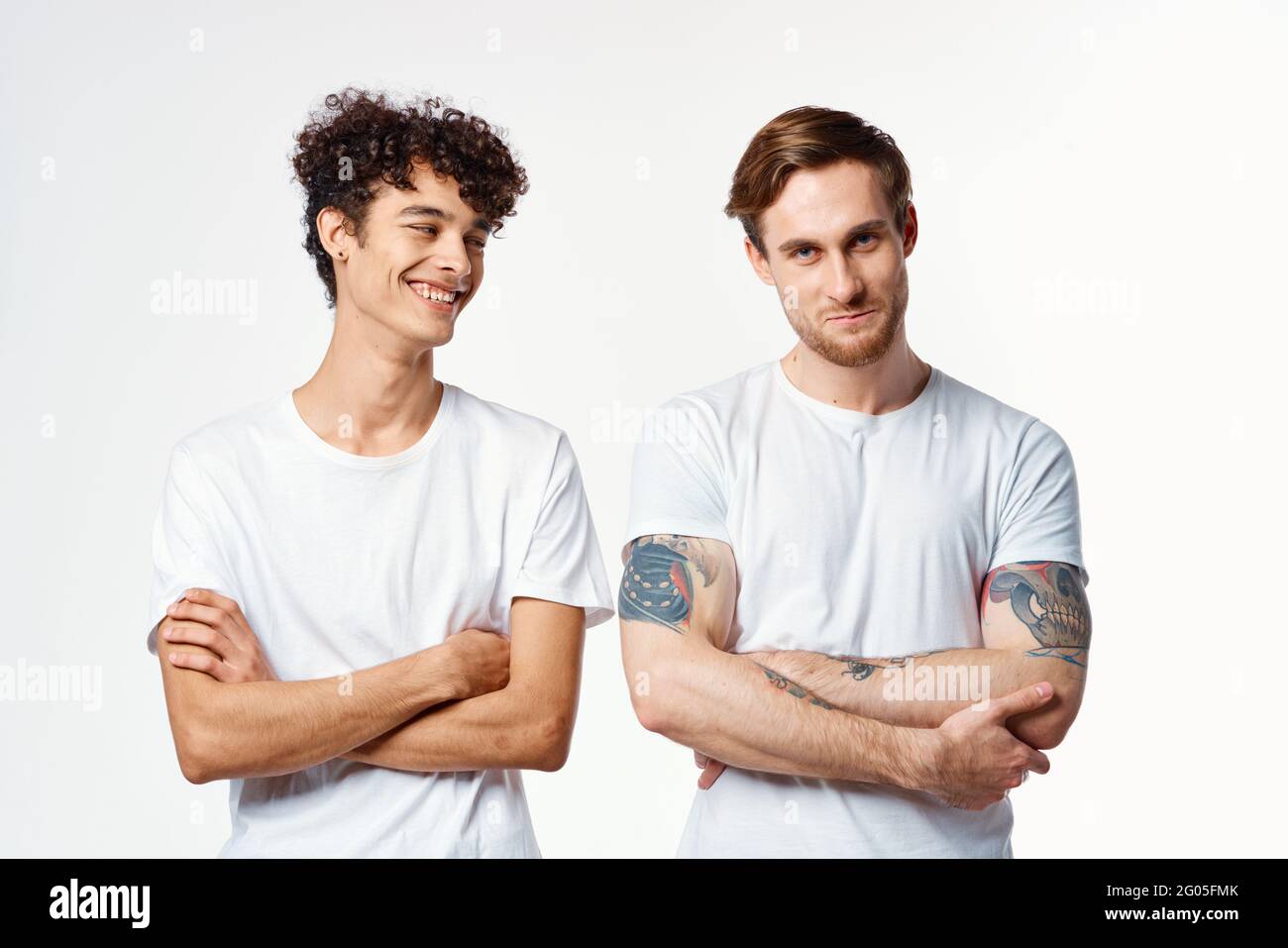 two men in white t-shirts stand side by side cropped view studio ...