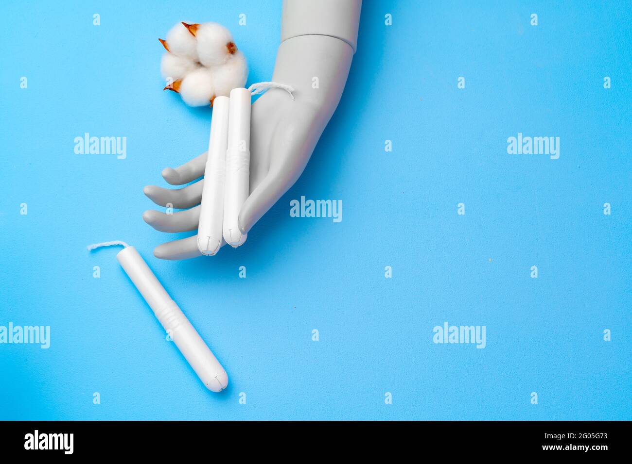 Female medical tampons and cotton flower on blue paper background Stock ...