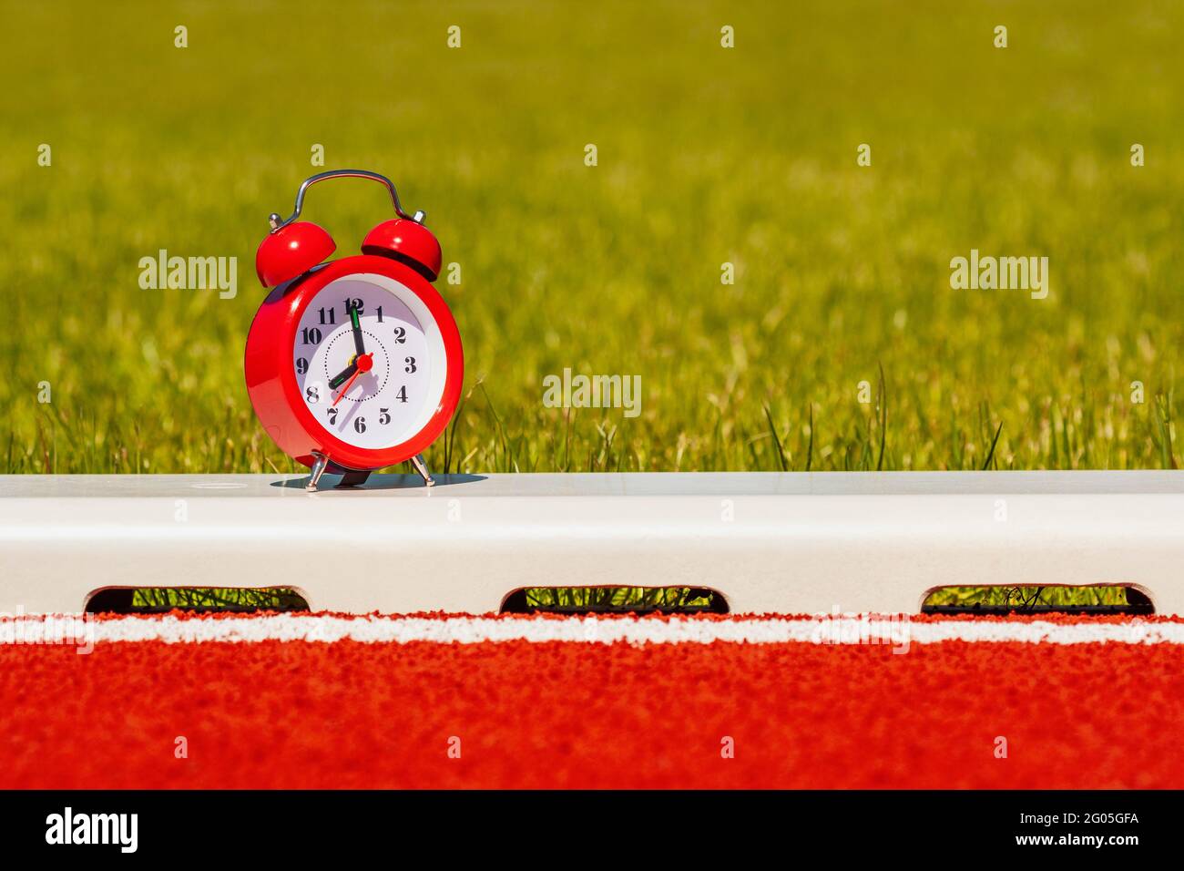 Red alarm clock on the running track in the stadium Stock Photo - Alamy