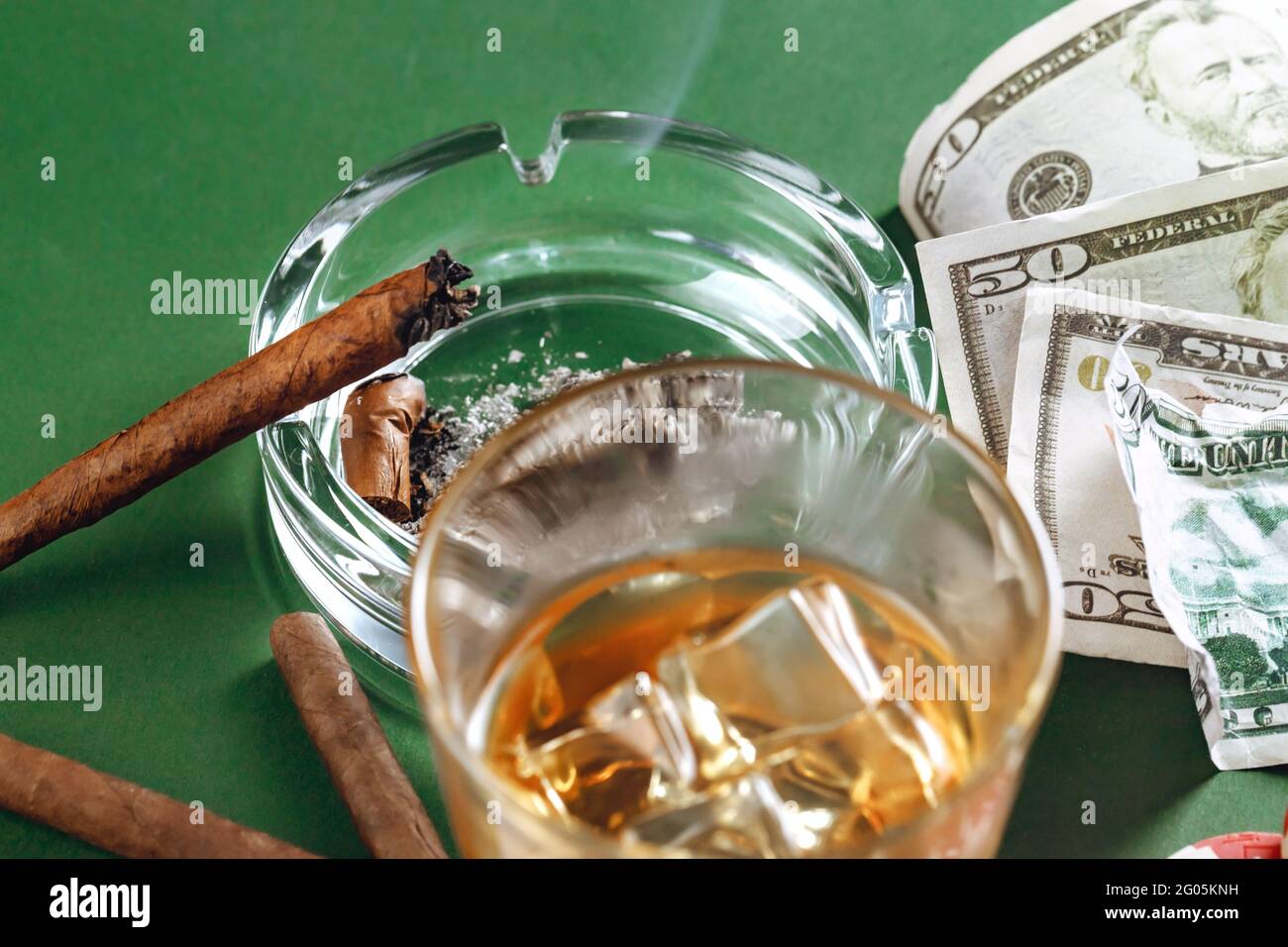 Cuban cigar and money on green background Stock Photo - Alamy