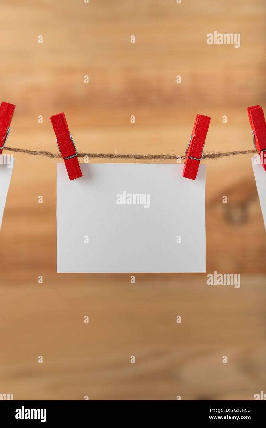 One blank white note card hanging with clothespin on rope string peg ...