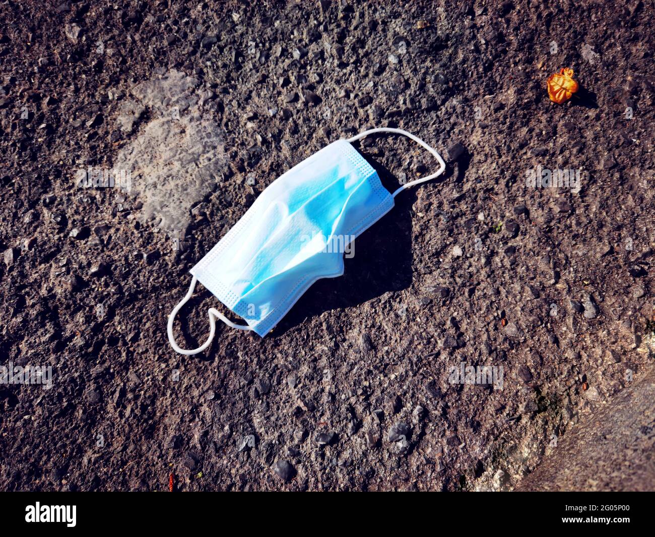 Used medical mask on the ground on the street. Environmental pollution ...