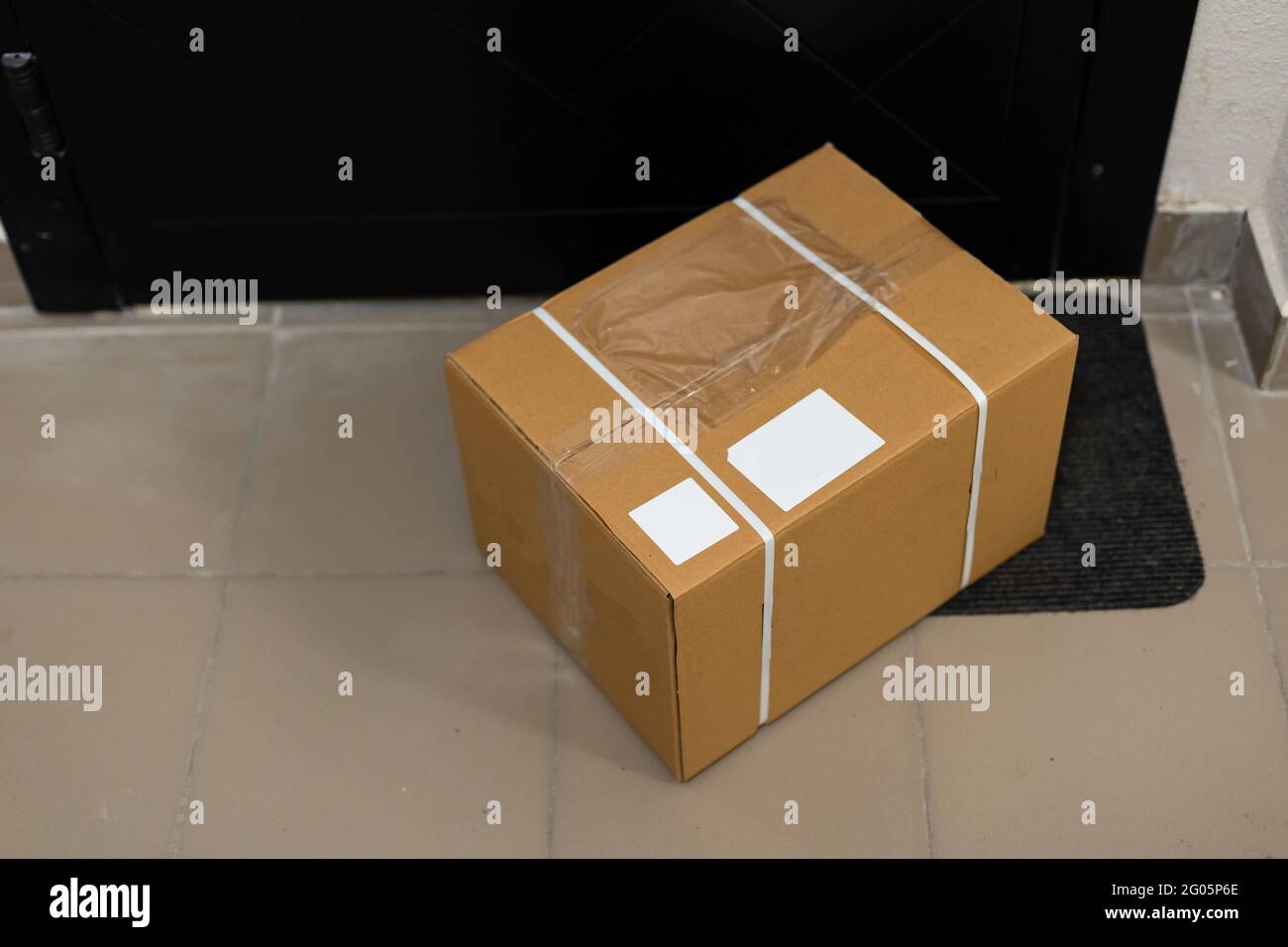 Cardboard box on rug near entrance door Stock Photo - Alamy