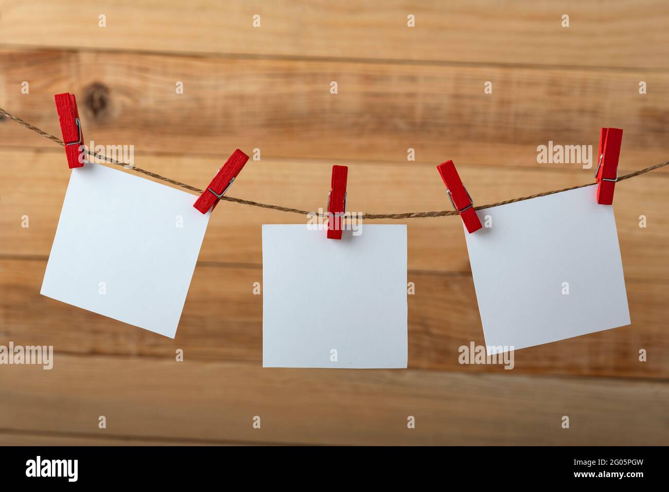 Three white blank note cards hanging with clothespins. Wooden ...