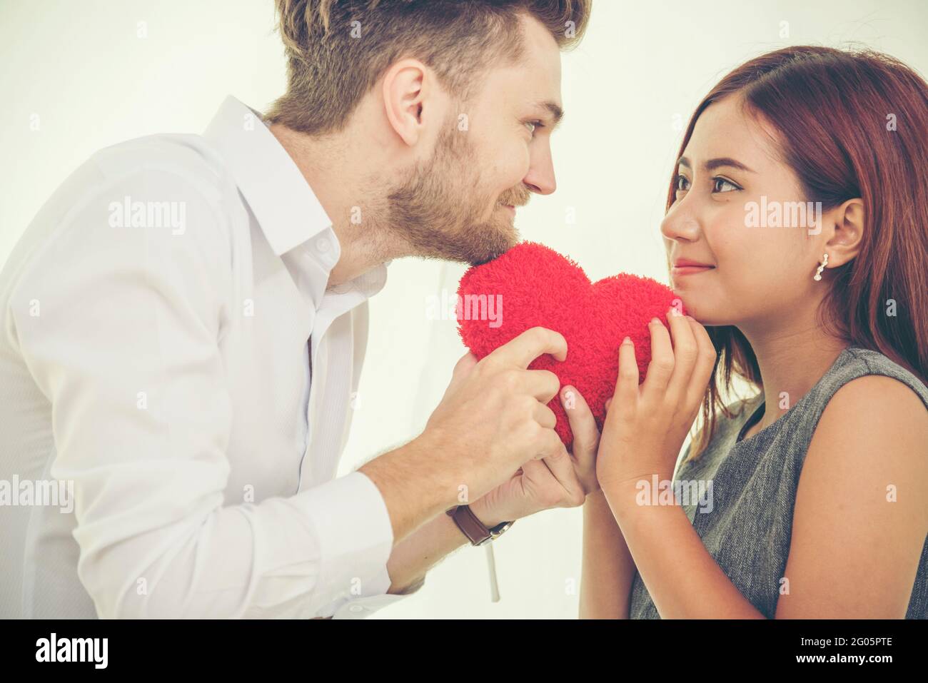 Couple lover in love holding red heart shape and looking in their eye ...