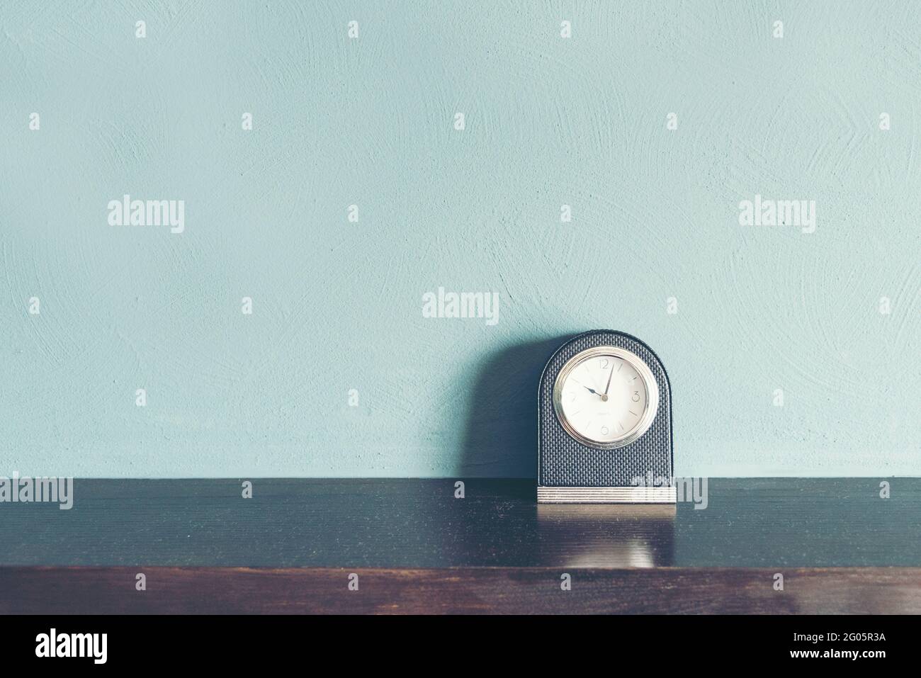 Black Clock at blue wall Time management Stock Photo - Alamy