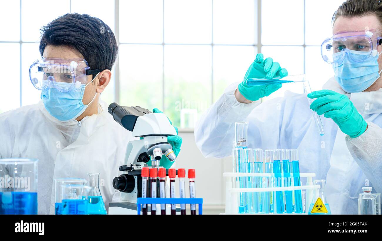 Couple male scientist wearing protection suit holding vaccine and ...