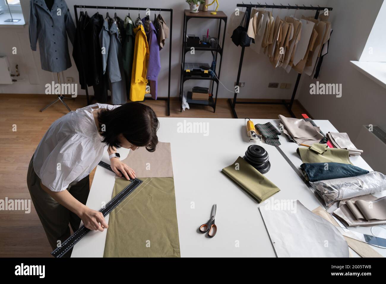 Design clothes, prepare fabric for sewing and cutting. Top view of girl ...