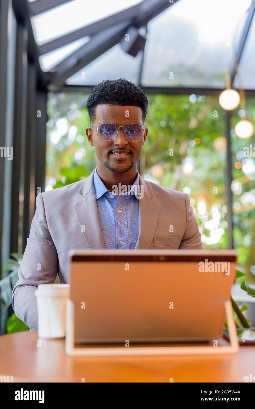 Portrait of handsome young African businessman wearing suit Stock Photo ...
